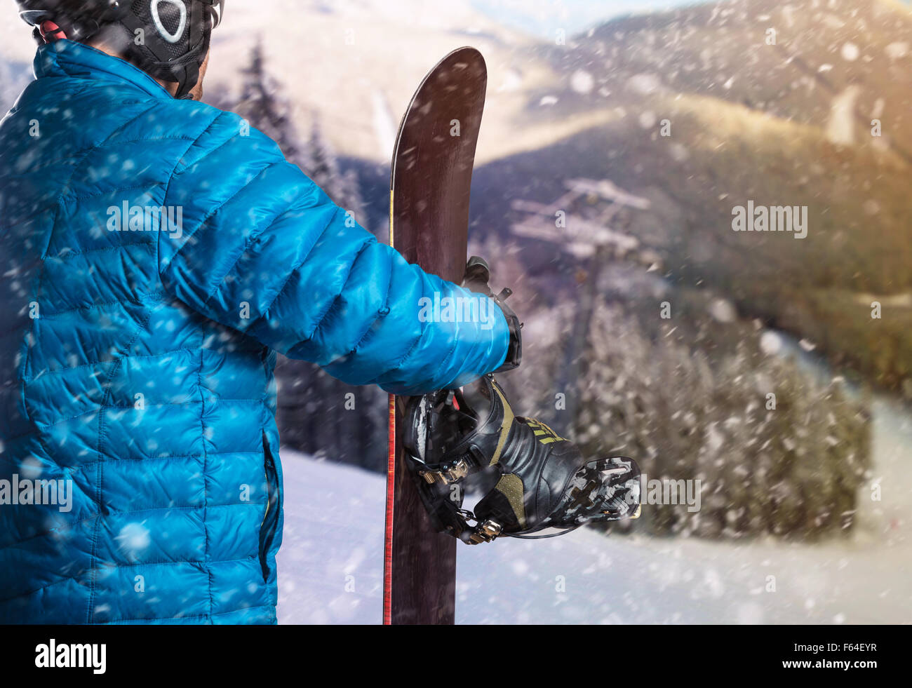 Snowboarder standing turned back and looking at the mountains Stock ...