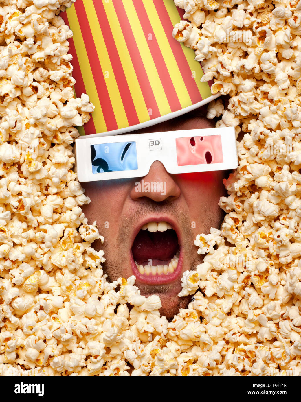 Surprised face in popcorn with bucket on head watching 3D movie Stock ...