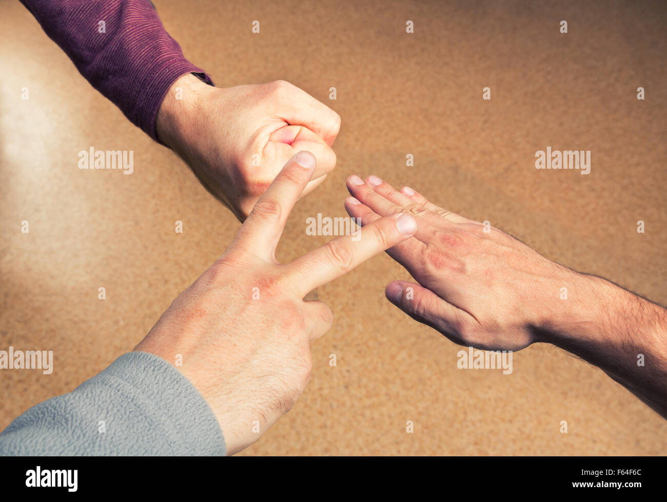 Hands playing paper rock scissors on brown background Stock Photo - Alamy
