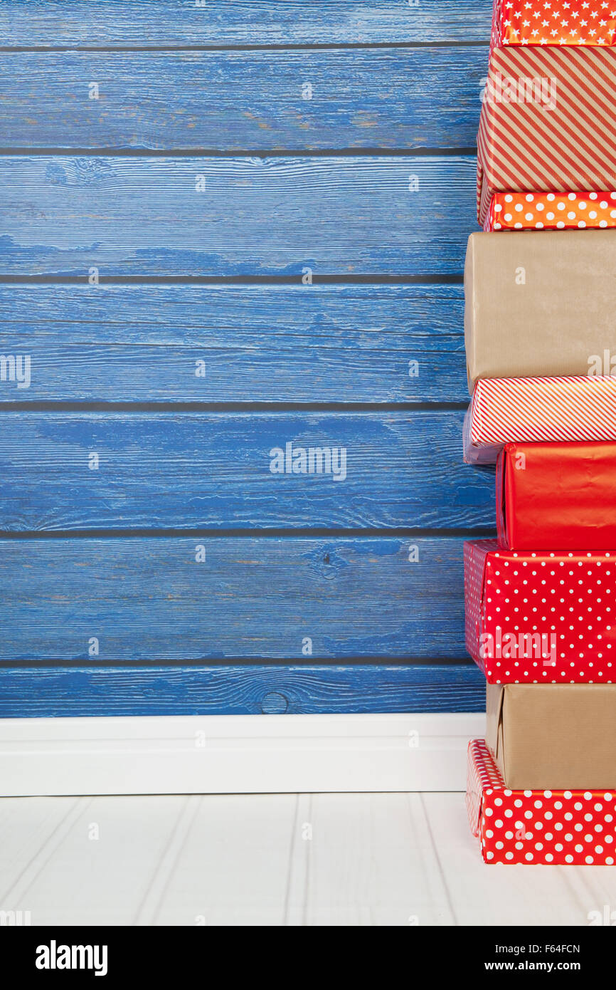 Red presents on white floor with blue wooden wall Stock Photo - Alamy