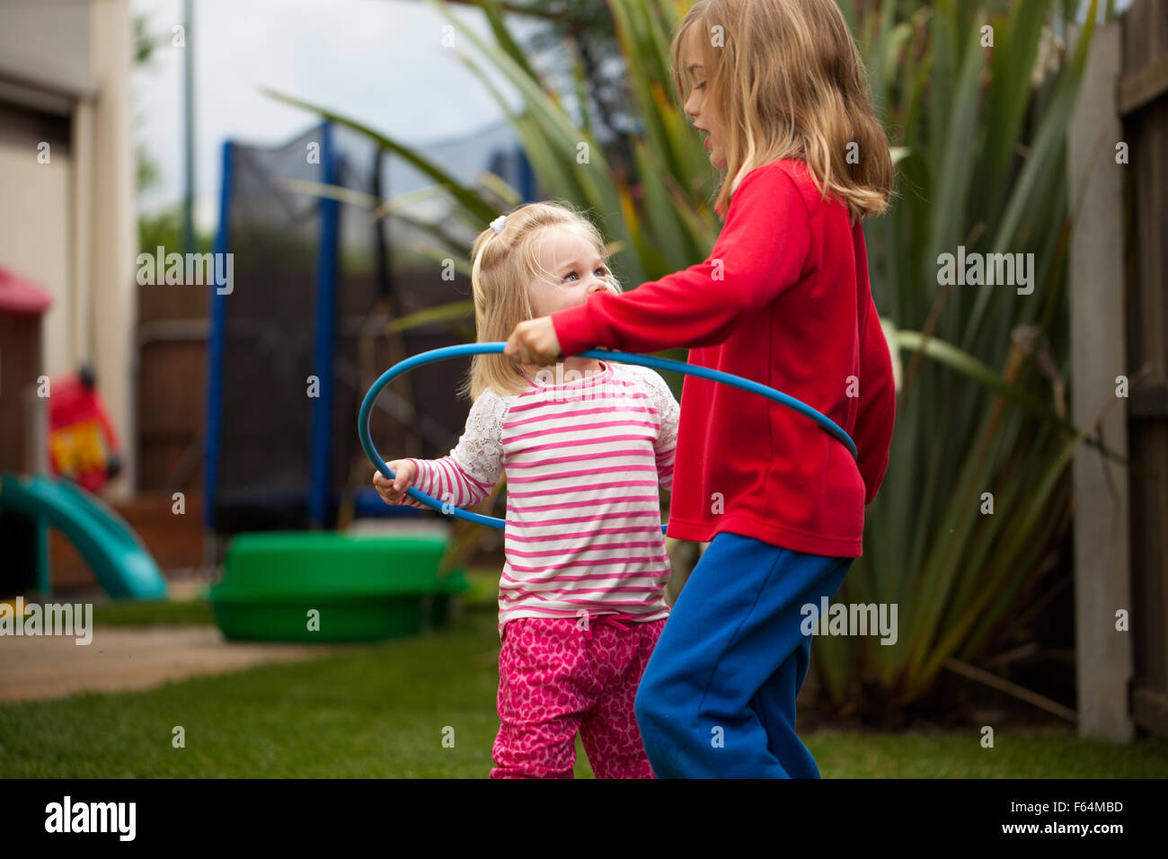 Two little girls in a hula hoop Stock Photo - Alamy