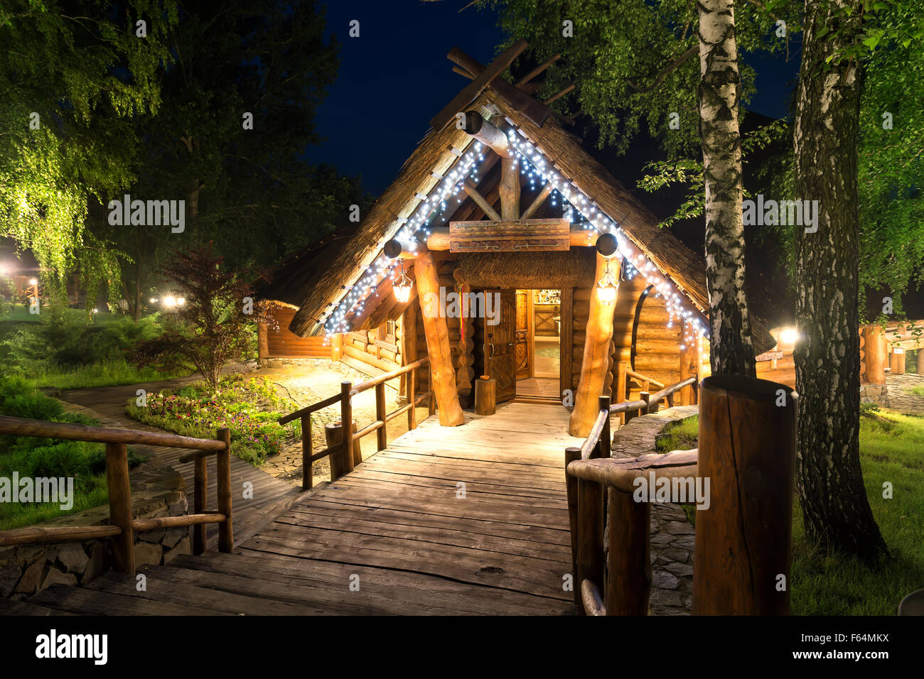 Wooden cottage in forest lit by lanterns at night Stock Photo - Alamy
