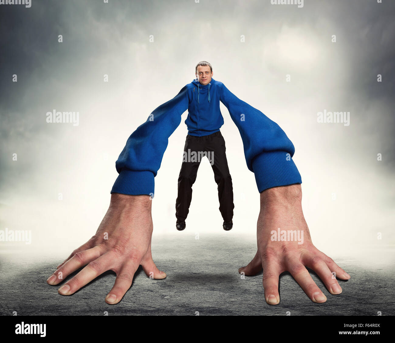 Strange man stands on big hands over grey background Stock Photo - Alamy