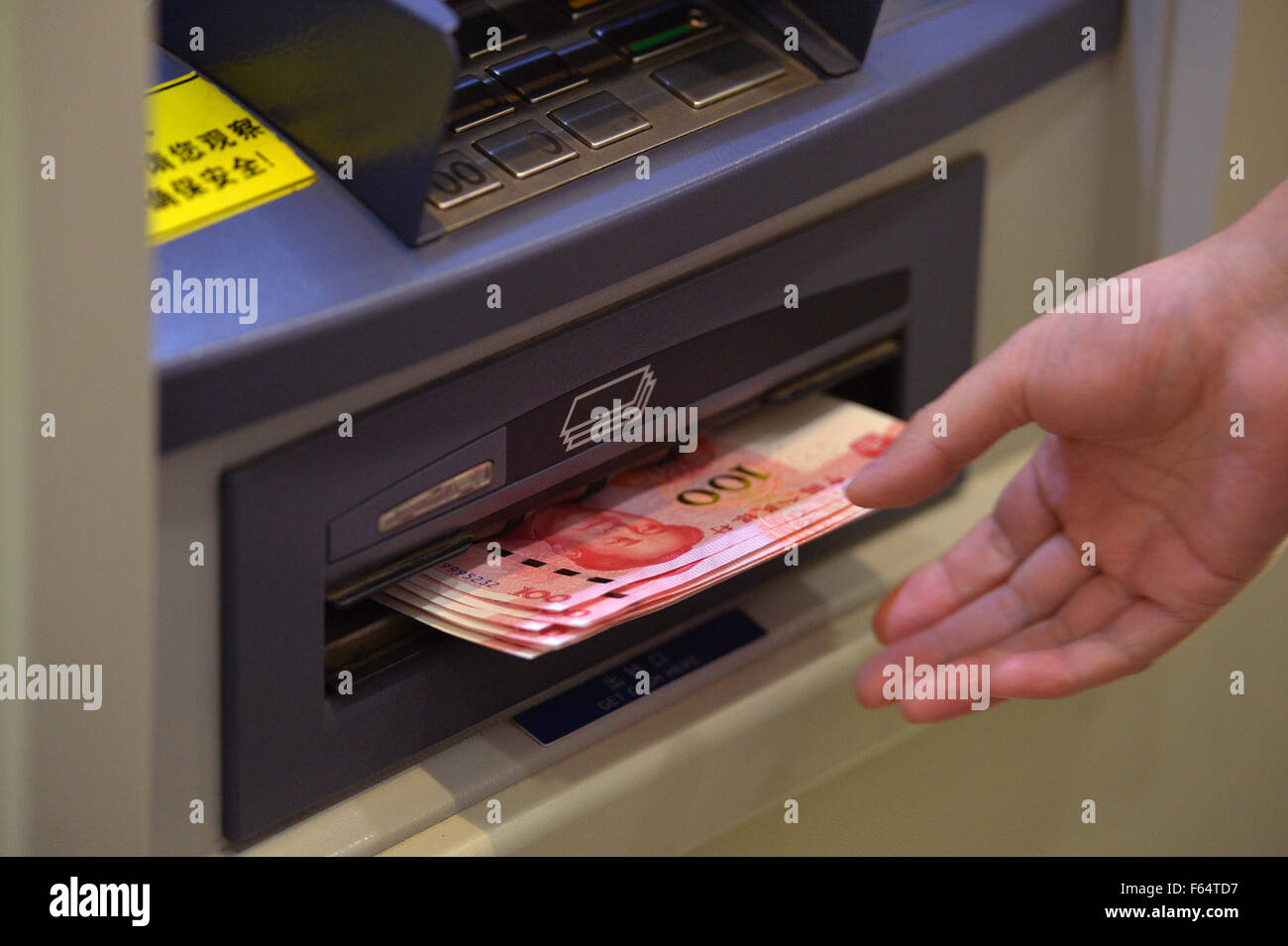 Beijing, China. 12th Nov, 2015. A resident withdraws new 100-yuan ...