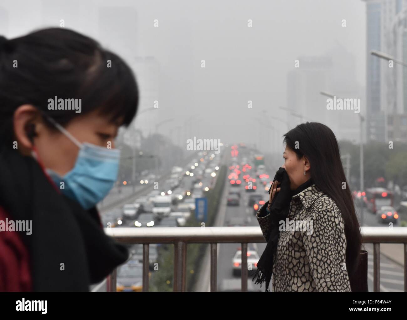 Beijing, China. 12th Nov, 2015. Pedestrians wearing masks walk amid ...