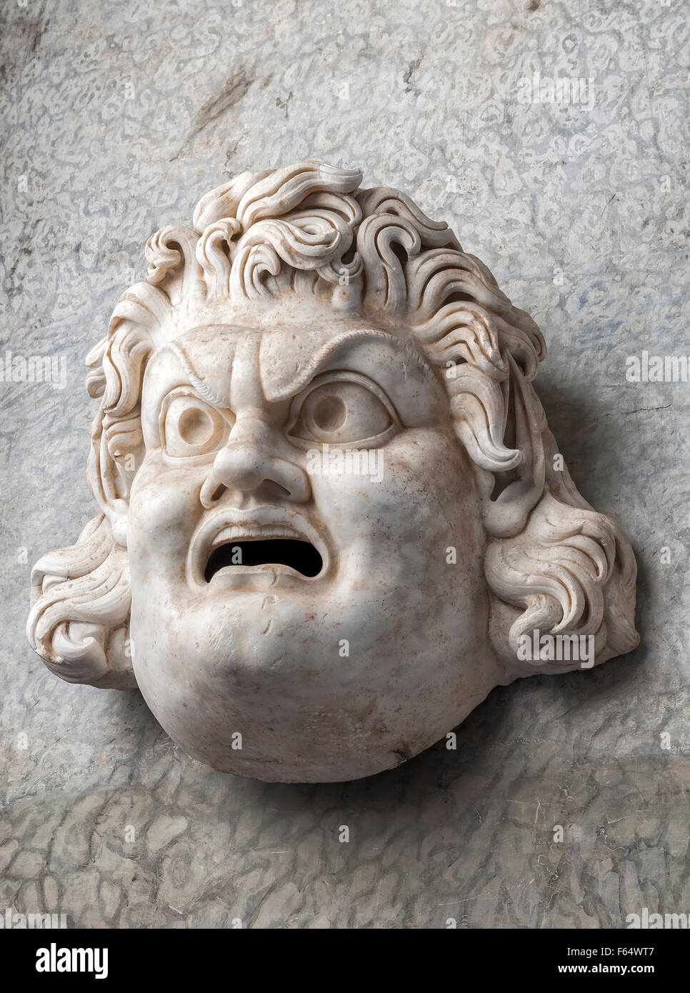 Ancient roman head statue showing anger on a wall in the Vatican city ...