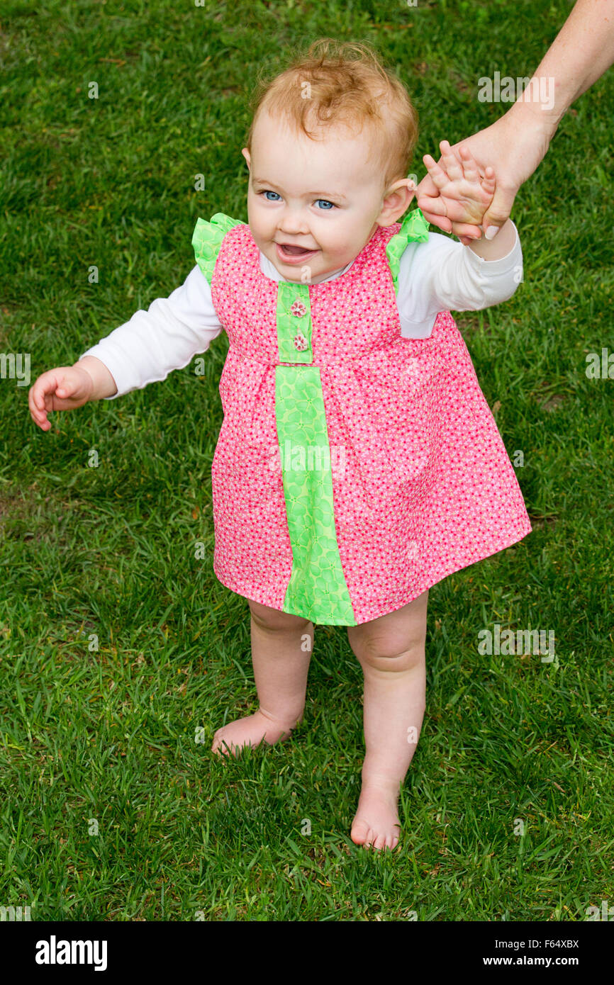 Cute toddler learning balance, getting a supporting hand Stock Photo ...