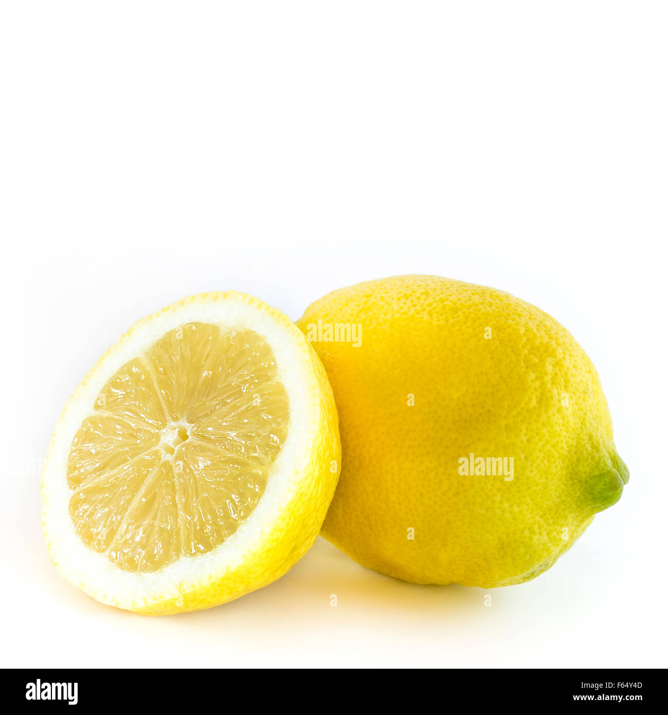 A whole lemon and one cut in half, isolated on white backdrop Stock ...