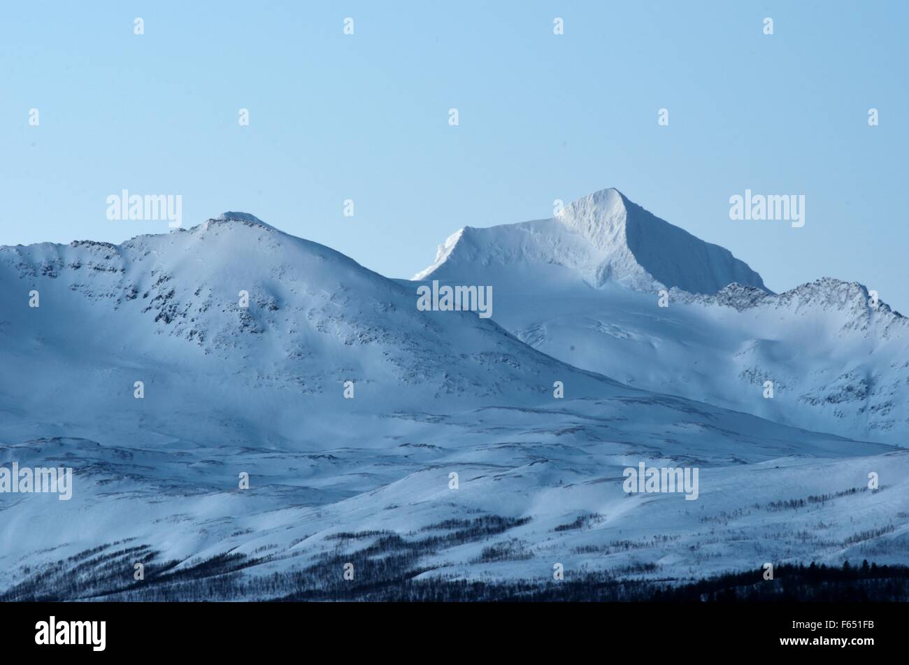mighty white jagged mountain peak on blue winter sky Stock Photo - Alamy