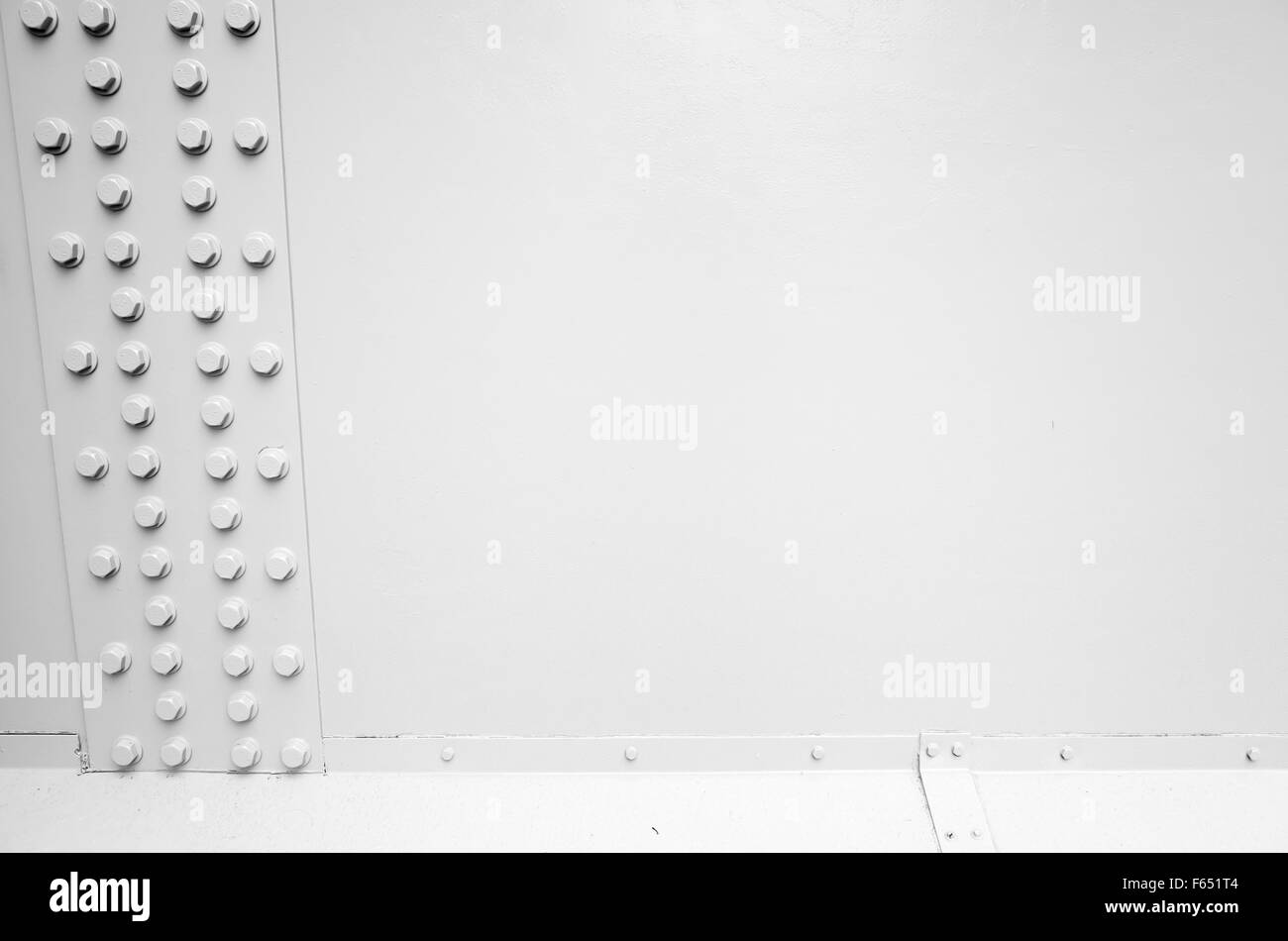 White steel wall with bolts in a row, metal parts connection ...