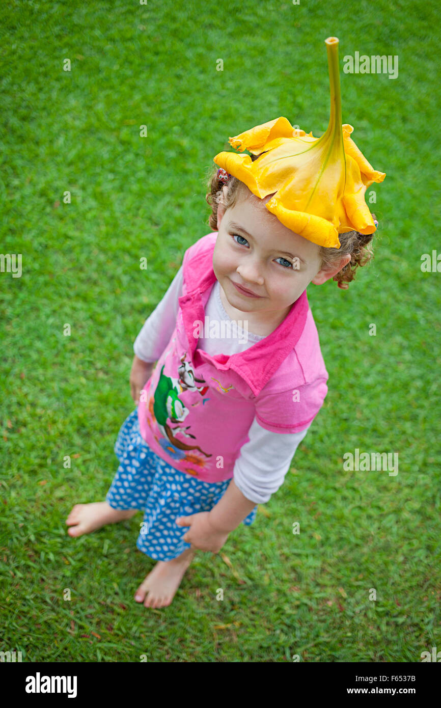Girl with a large yellow trumpet flower hat Stock Photo - Alamy