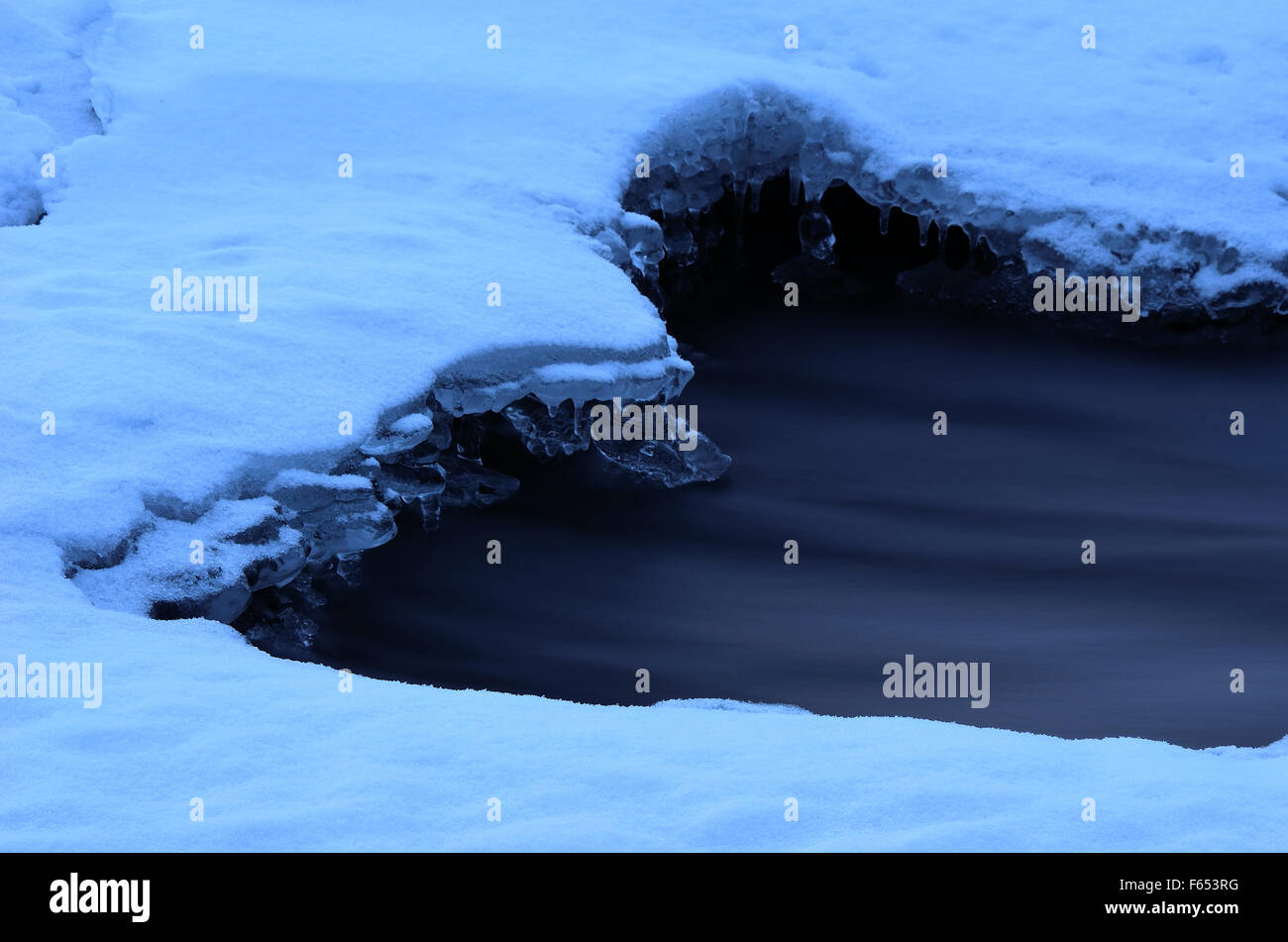 hole in river ice in winter and beautiful frozen ice shapes and water ...