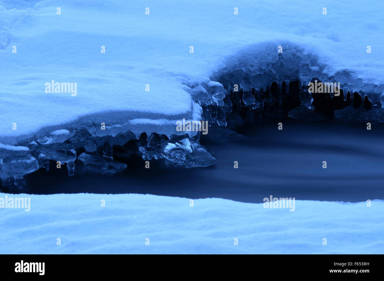 hole in river ice in winter and beautiful frozen ice shapes and water ...