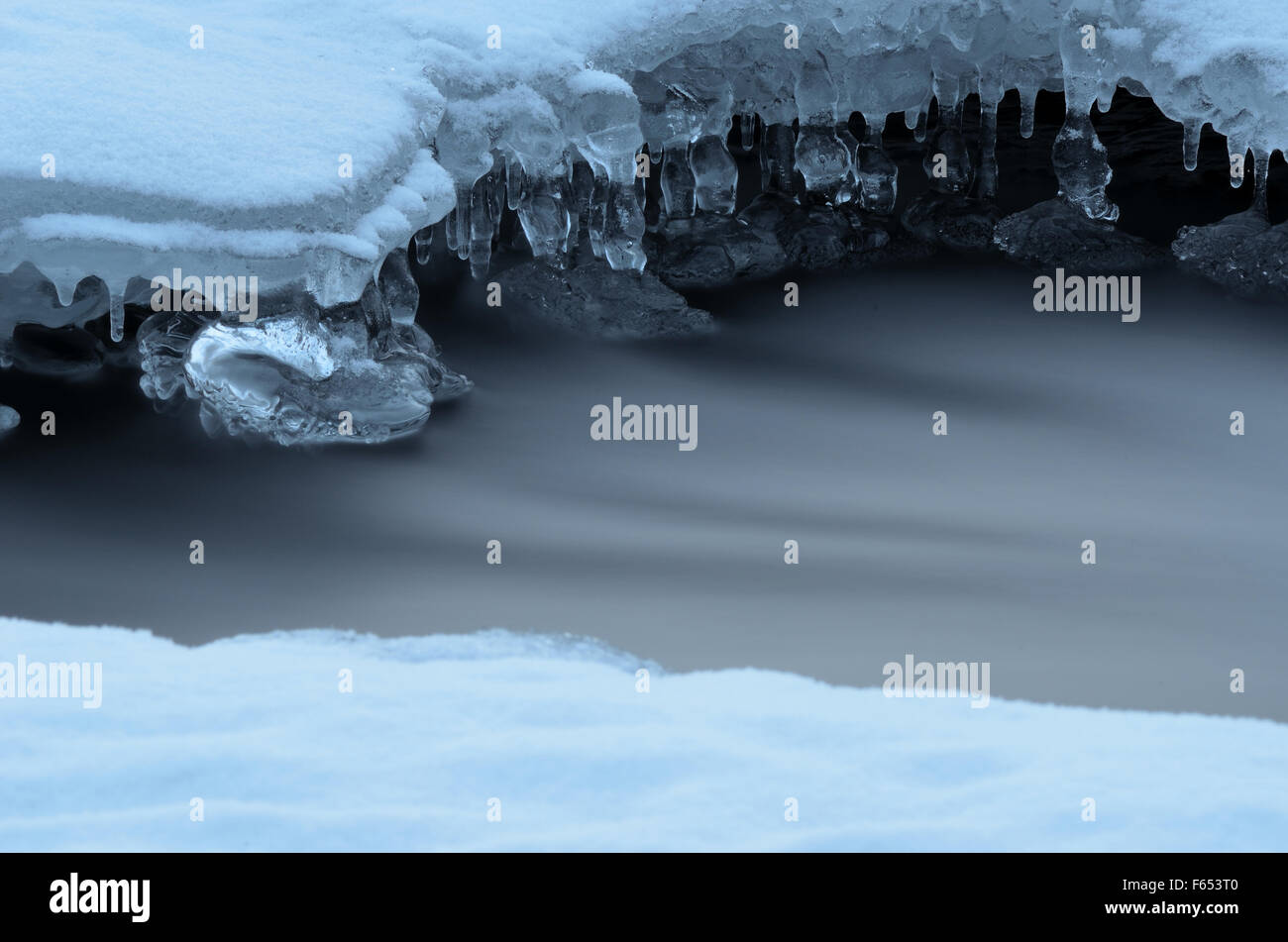 hole in river ice in winter and beautiful frozen ice shapes and water ...