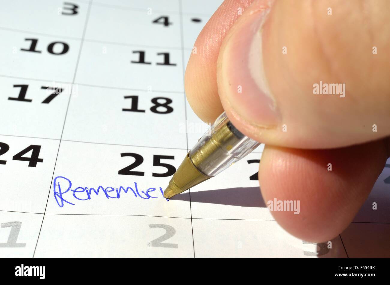 human hand writing remember on a date on a blank calendar Stock Photo ...