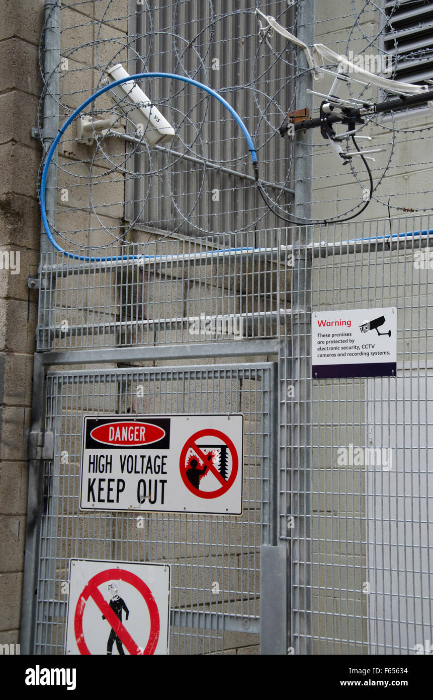 A surveillance or security CCTV camera mounted high on an exterior wall ...