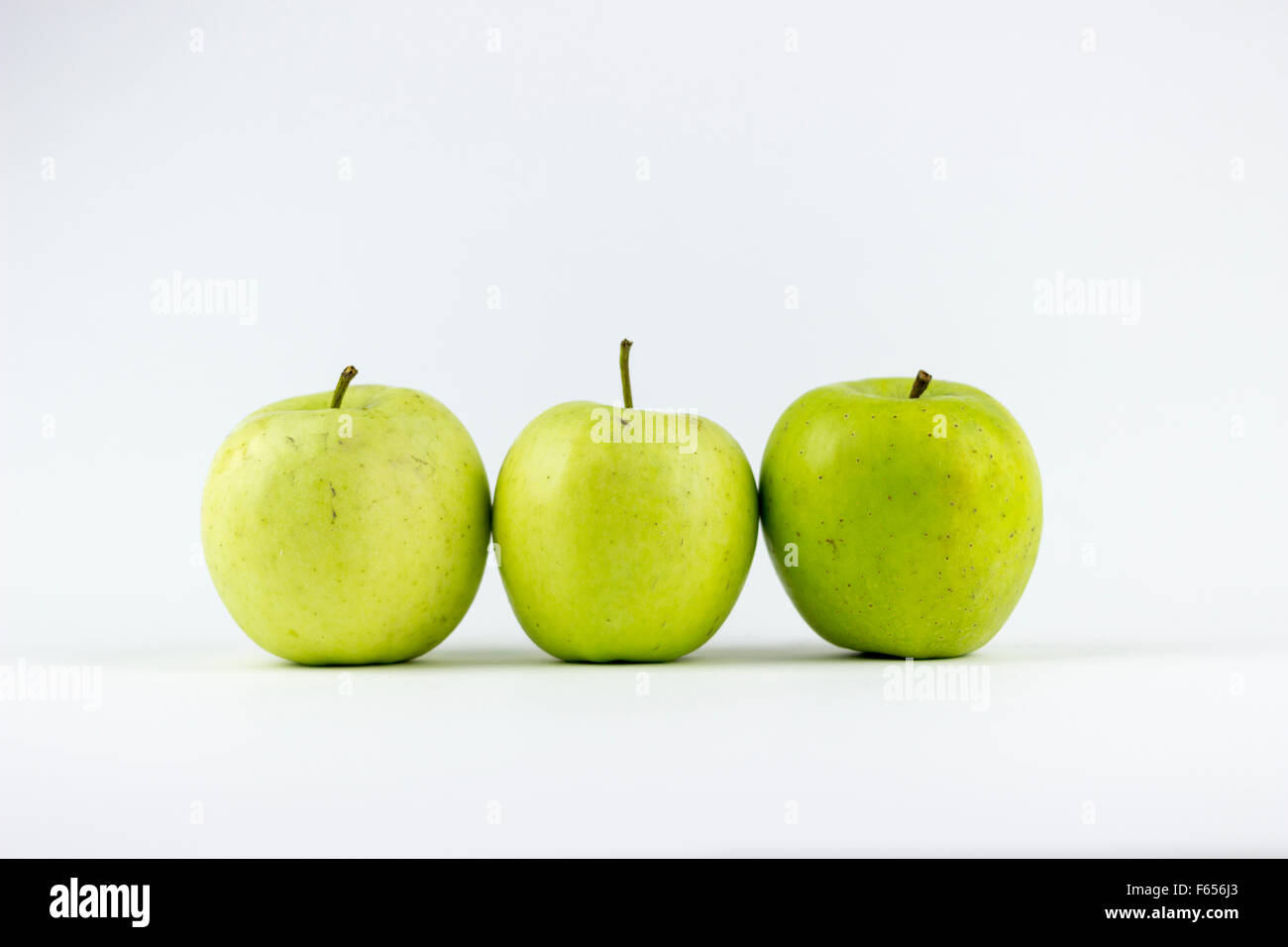 Three green apples, isolated on a white background Stock Photo - Alamy