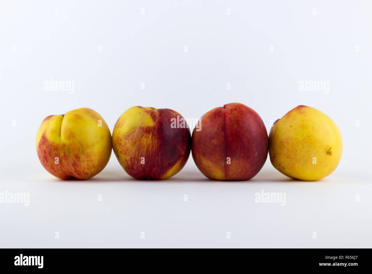 Four peaches on a white background Stock Photo - Alamy