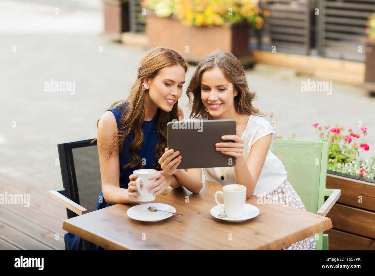 young women with tablet pc and coffee at cafe Stock Photo - Alamy