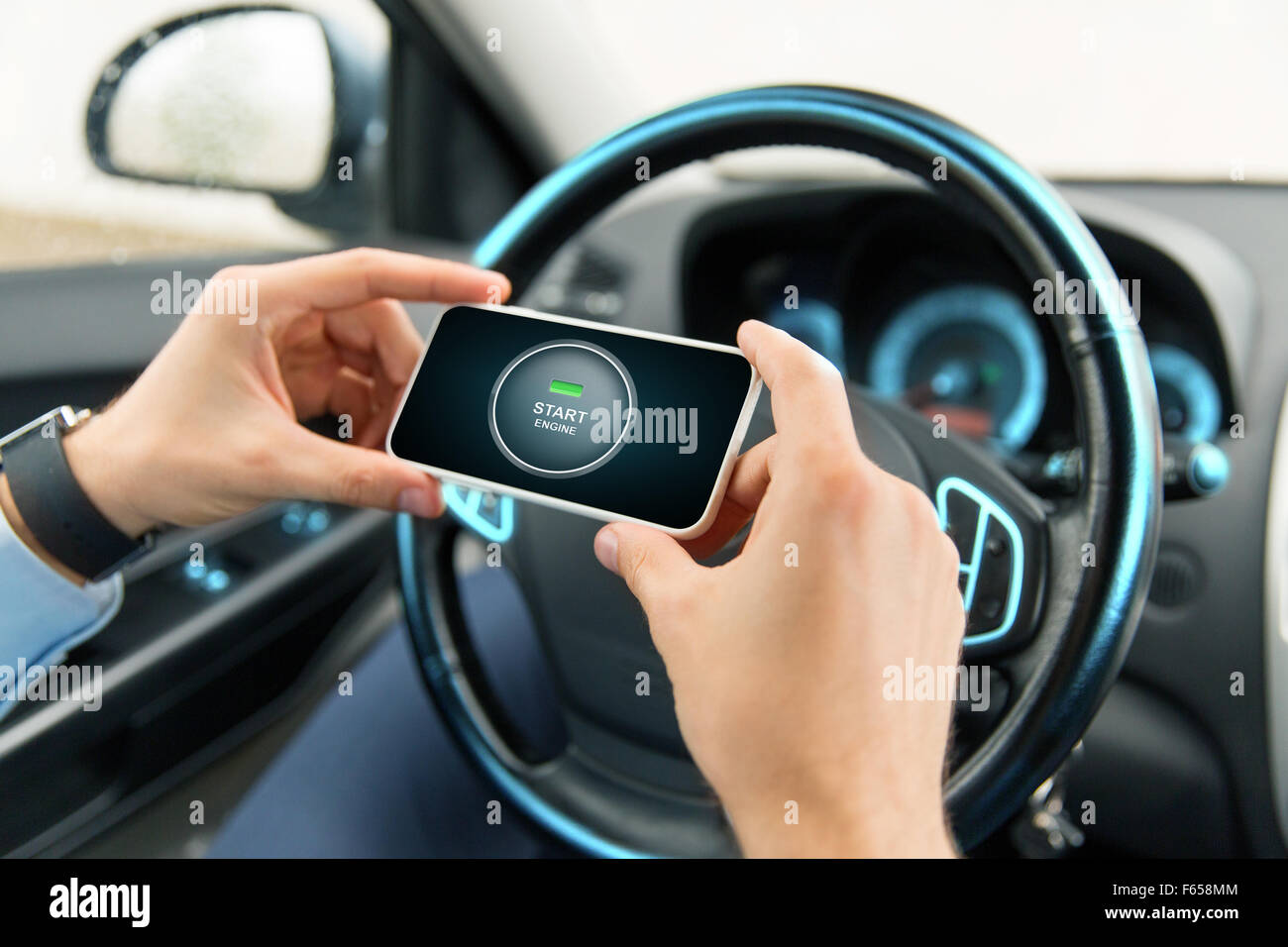hands with start engine icon on smartphone in car Stock Photo - Alamy