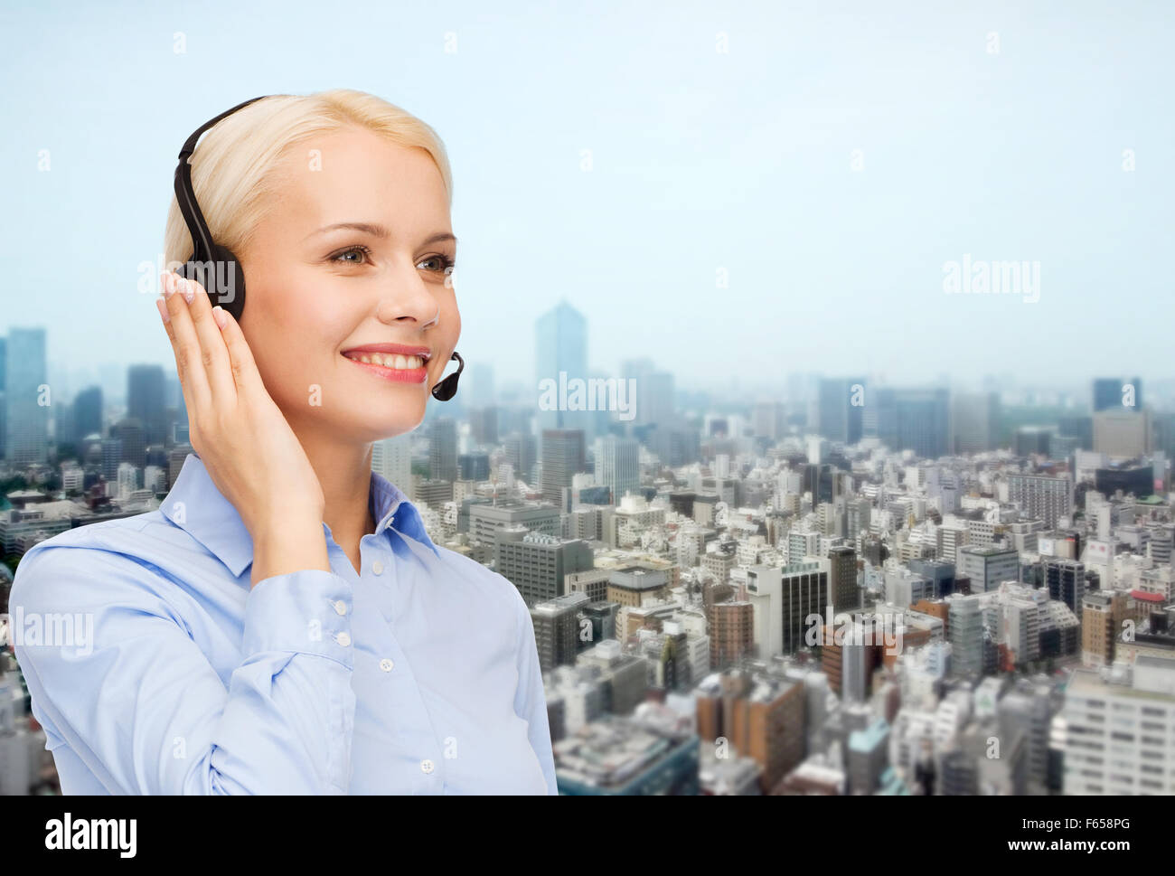 helpline operator in headset over city background Stock Photo - Alamy