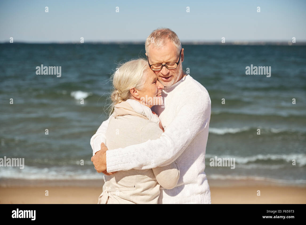 happy senior couple hugging on summer beach Stock Photo - Alamy