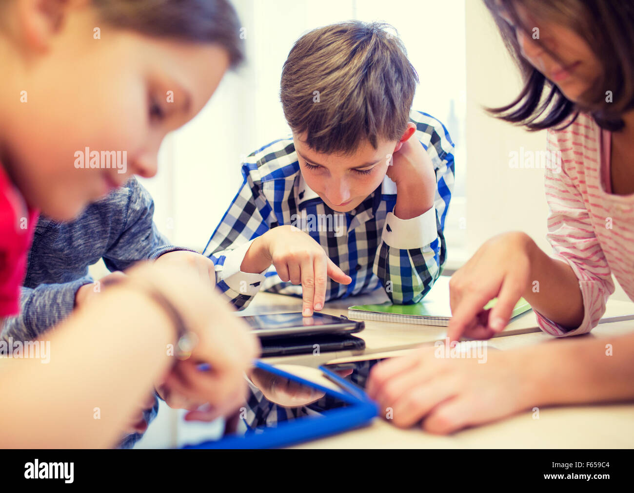group of school kids with tablet pc in classroom Stock Photo - Alamy