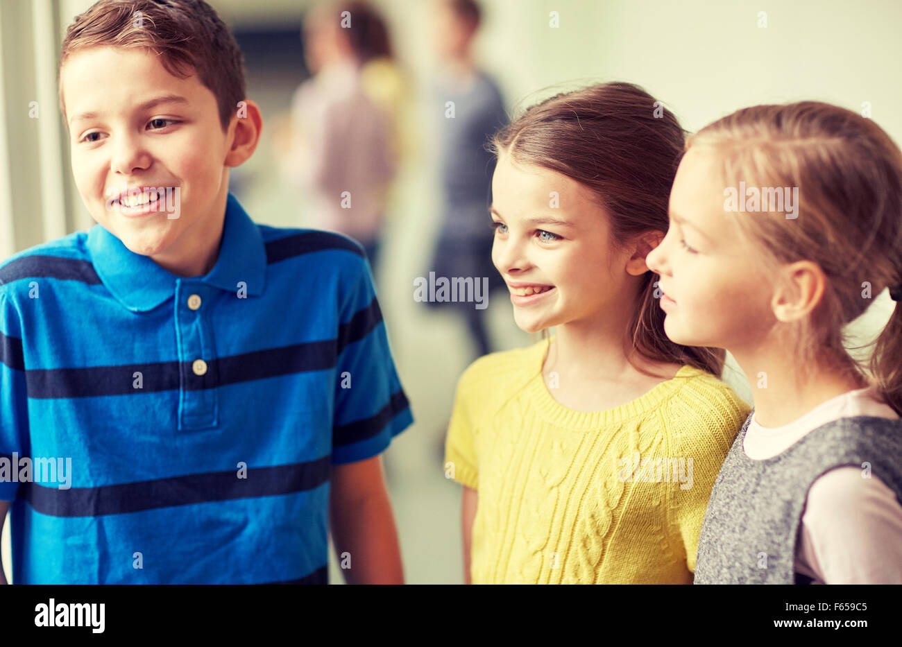 group of smiling school kids talking in corridor Stock Photo - Alamy