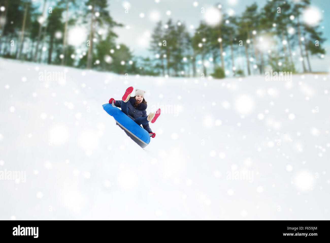 happy teenage girl sliding down on snow tube Stock Photo - Alamy