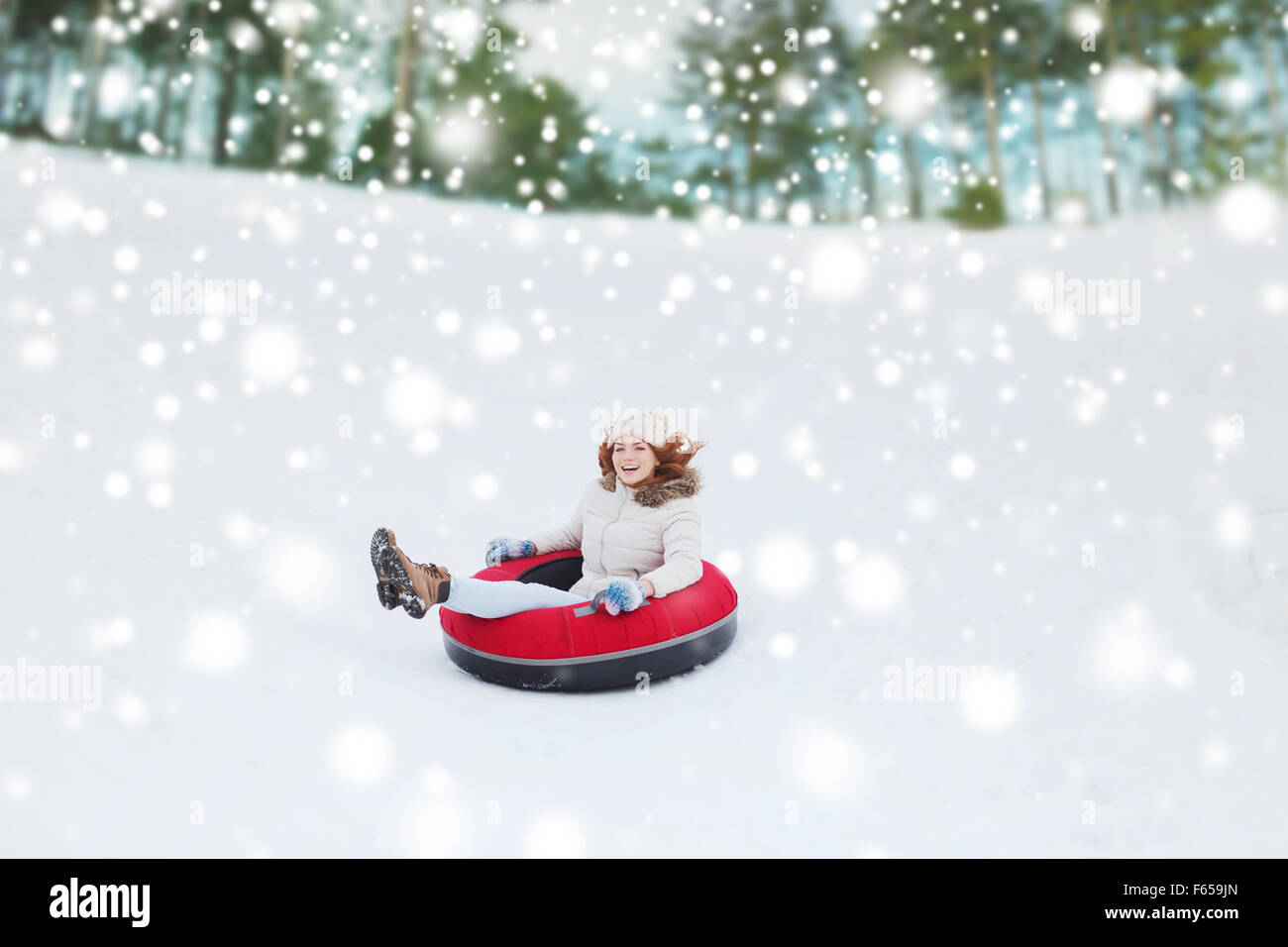 happy teenage girl sliding down on snow tube Stock Photo - Alamy