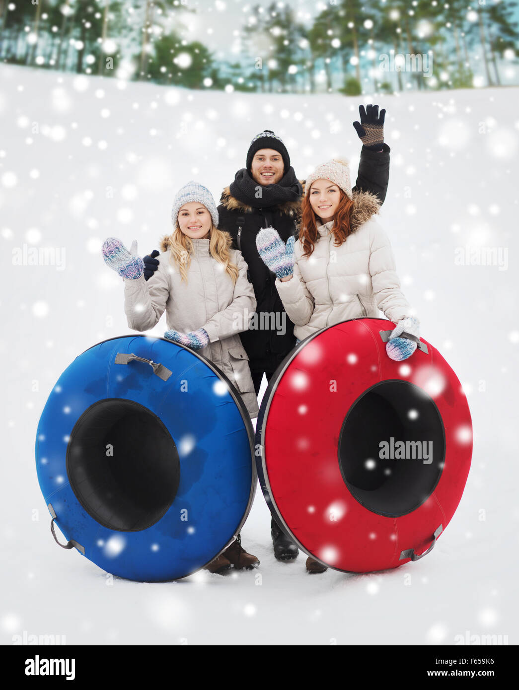 group of smiling friends with snow tubes Stock Photo - Alamy