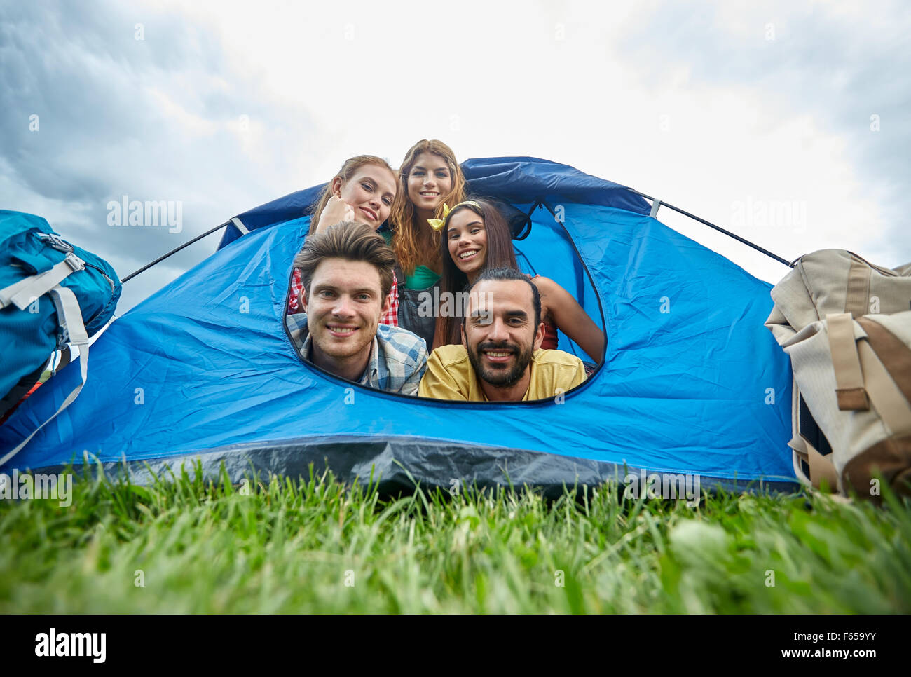 happy friends with backpacks in tent at camping Stock Photo - Alamy