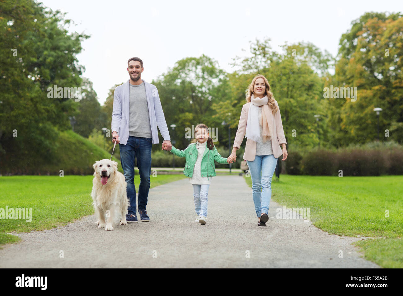 happy family with labrador retriever dog in park Stock Photo - Alamy