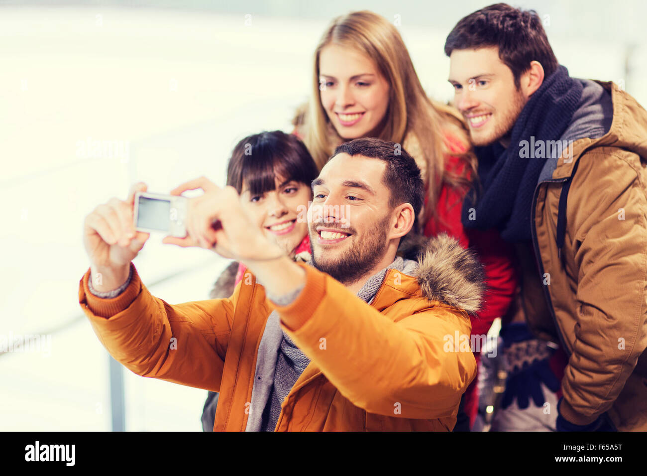 happy friends with camera on skating rink Stock Photo - Alamy