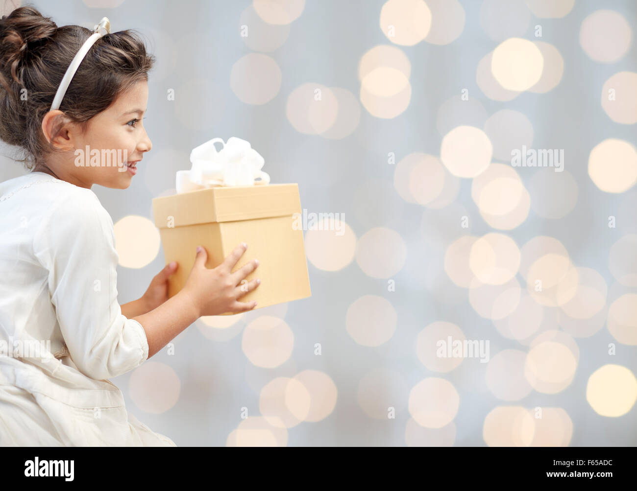 happy little girl with present over lights Stock Photo - Alamy