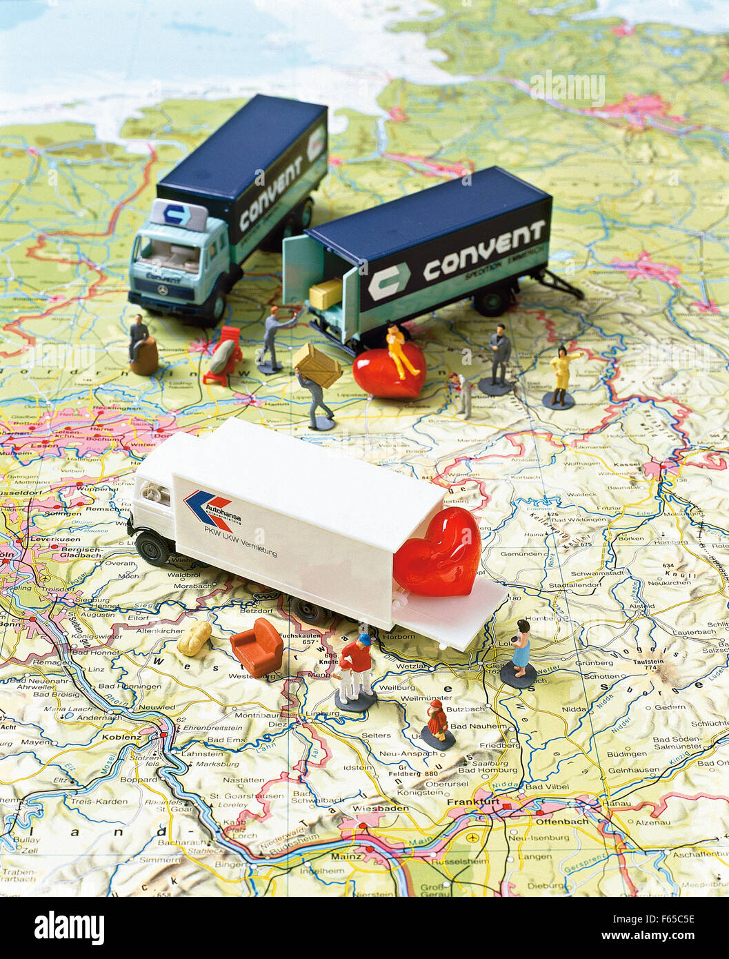Toy cars and human figurines on land map depicting long distance ...