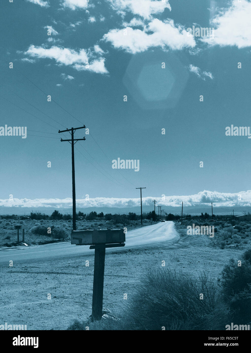 View of country road and electricity pylon on American desert landscape ...