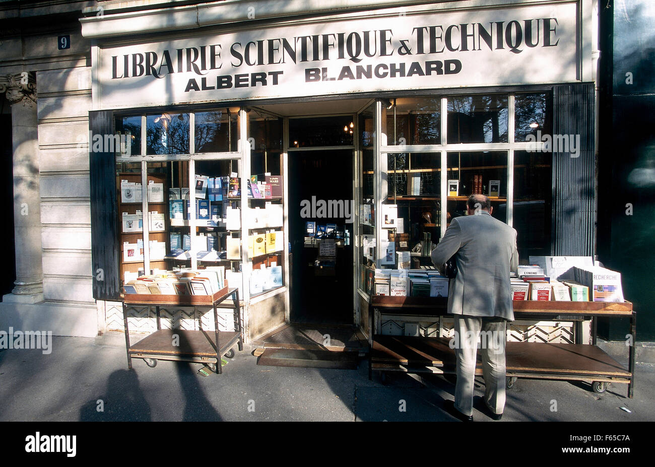 Customer buying books outside Library Albert Blanchard in Paris, France ...