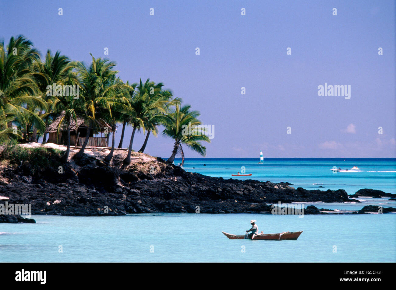 View of fishing hut, palm trees and lava rock in Comoros Stock Photo ...
