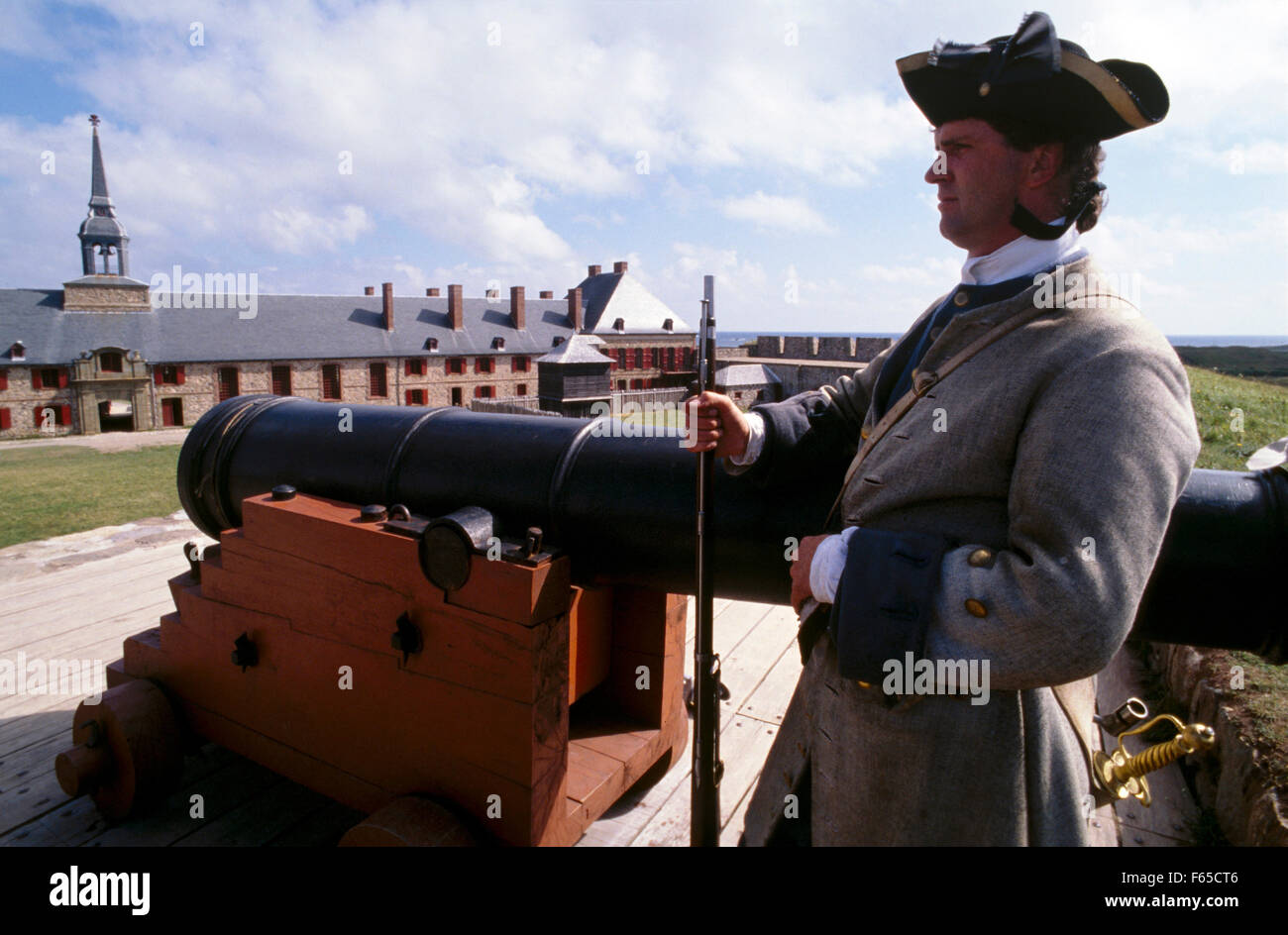 Soldier in uniform standing next to a canon in fort in Canada Stock ...