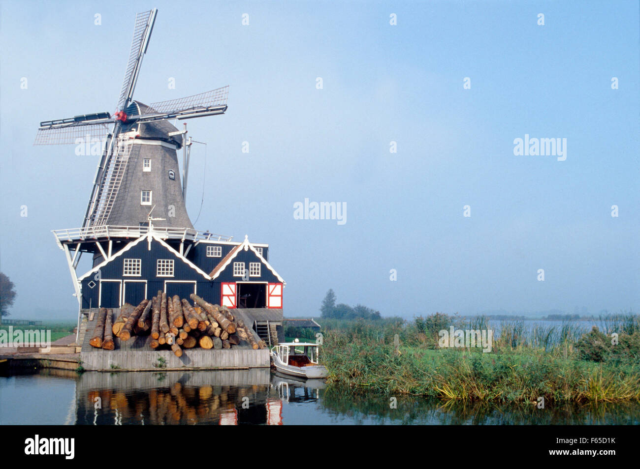 View of windmill on the lake against blue sky Stock Photo - Alamy