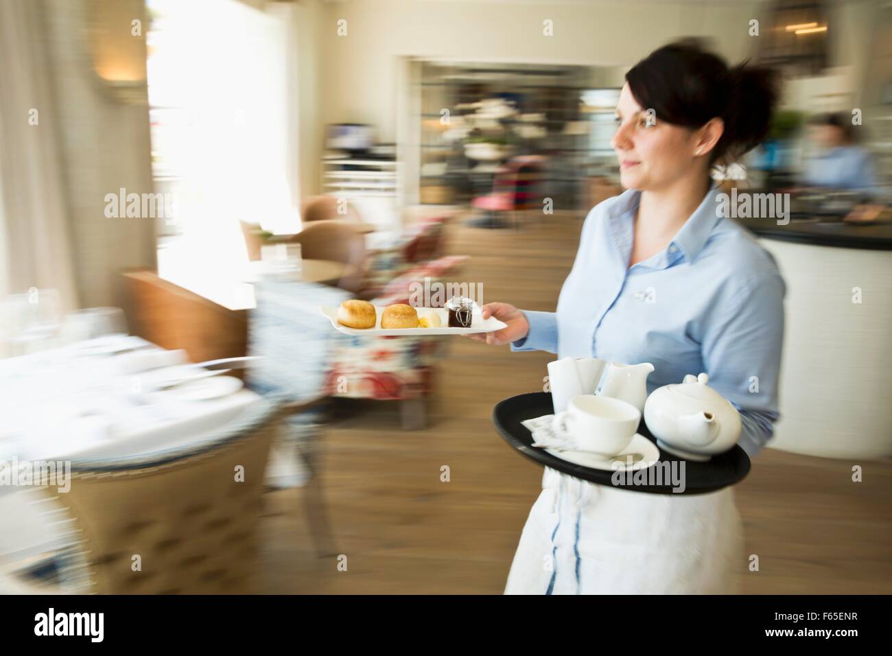 A waitress serving tea and cakes at The Idle Rock (Cornwall, England ...