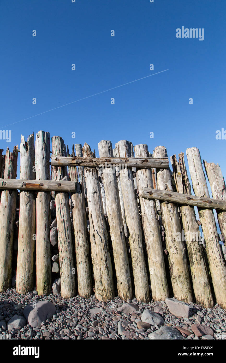 Wooden posts harbour wall at Porlock Weir coastline and beach on the ...