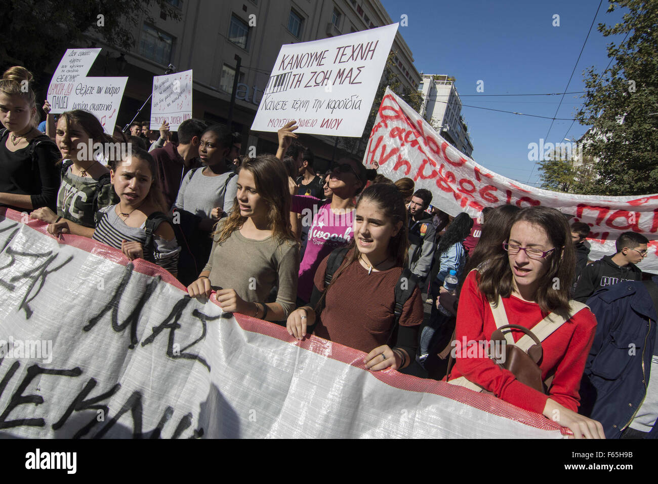 Protesters march towards the Greek Parliament holding banners and ...