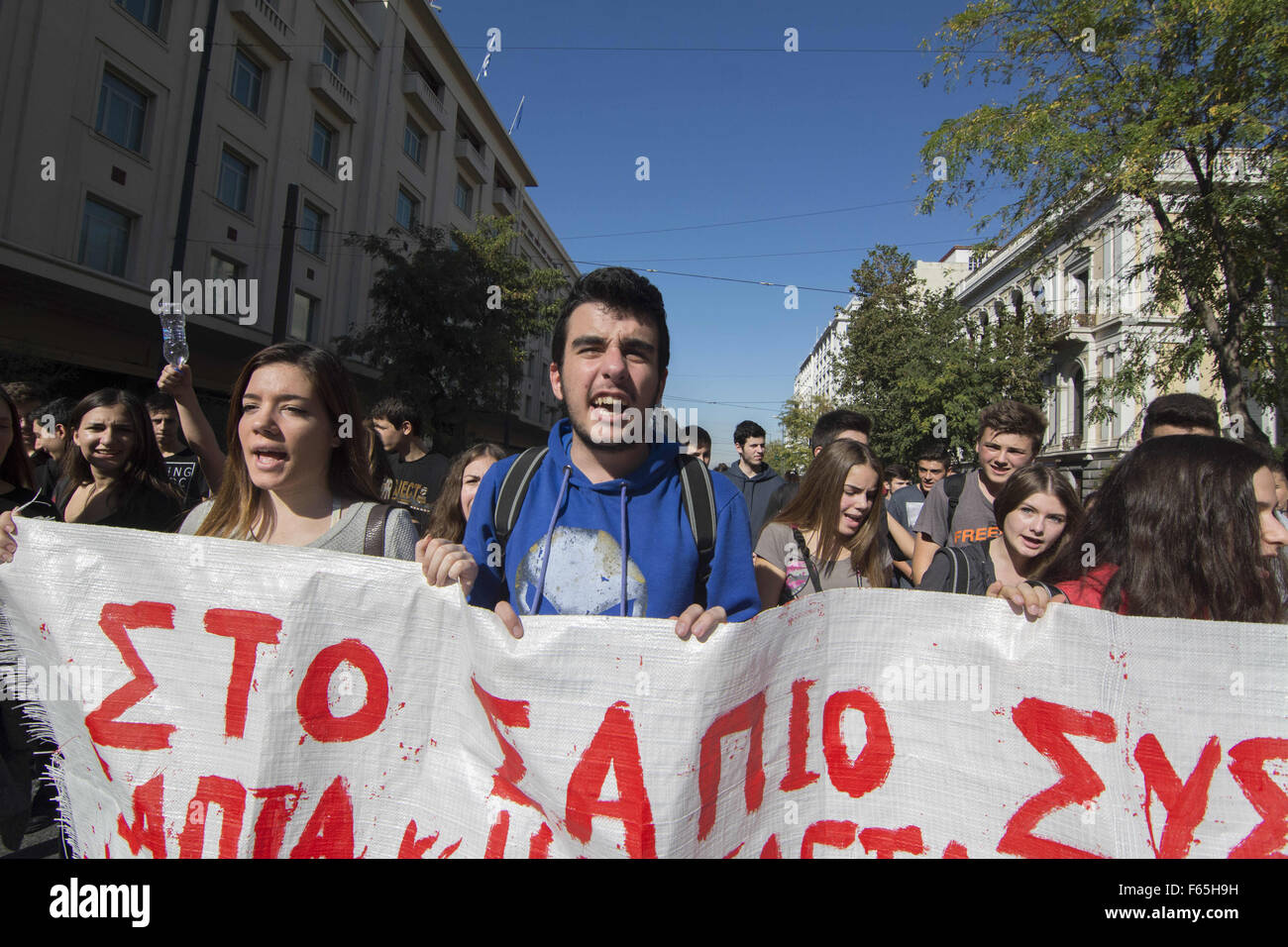 Protesters march towards the Greek Parliament holding banners and ...