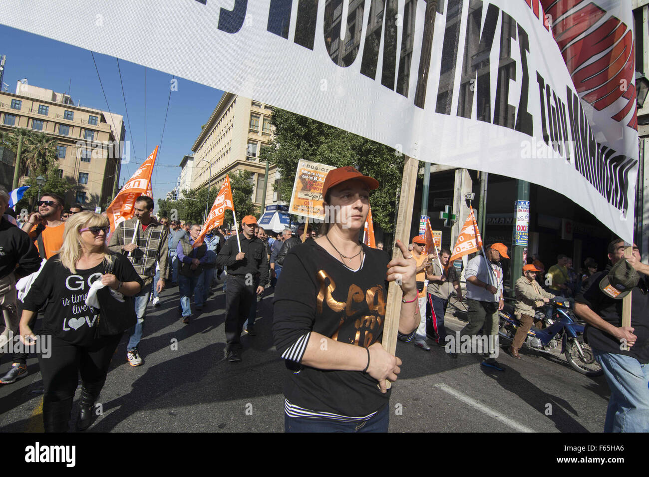 Protesters march towards the Greek Parliament holding banners and ...