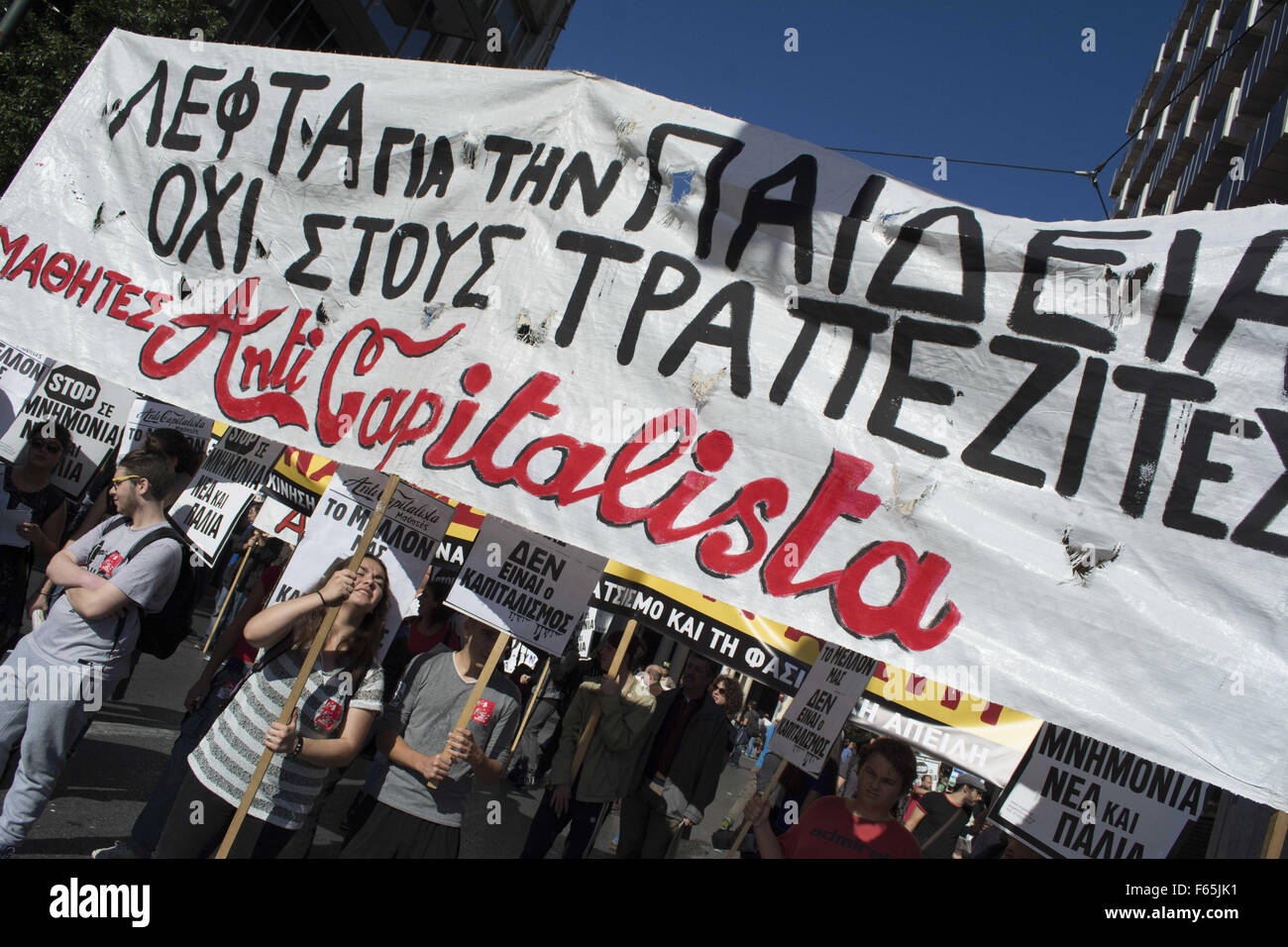 Protesters march towards the Greek Parliament holding banners and ...