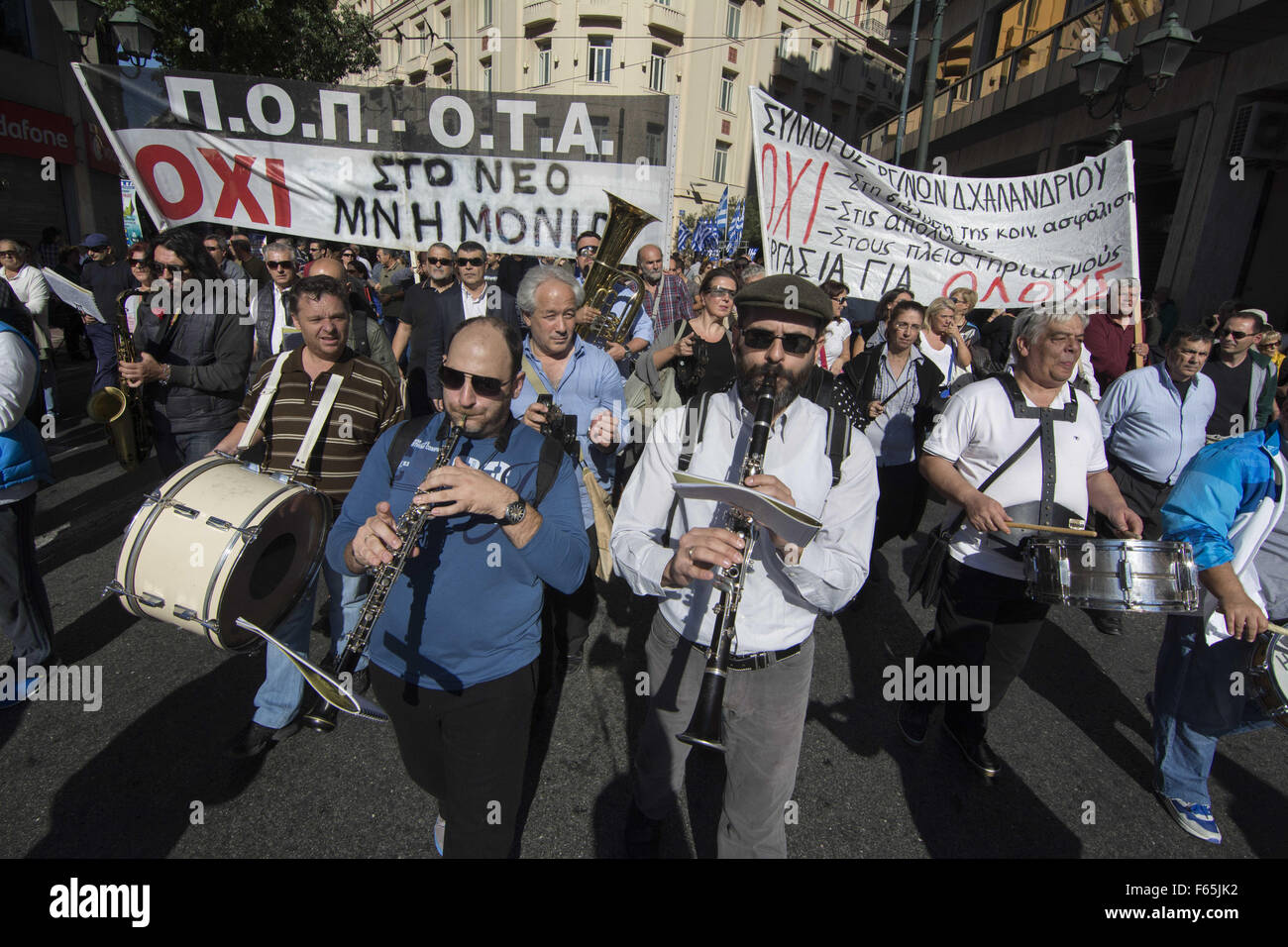 Protesters march towards the Greek Parliament holding banners and ...