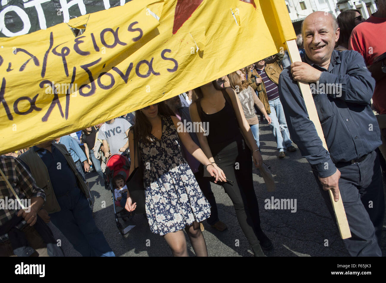 Protesters march towards the Greek Parliament holding banners and ...