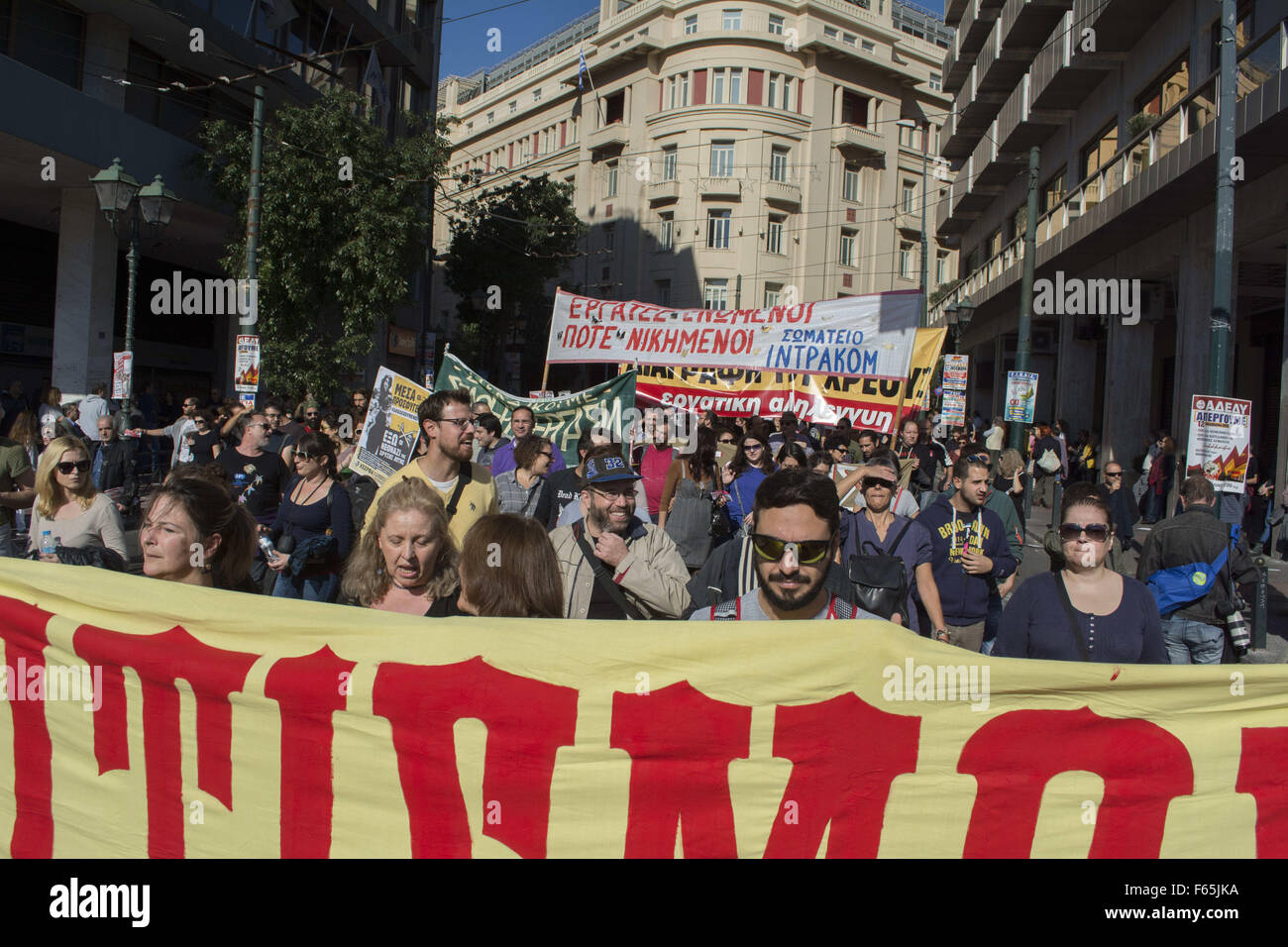 Protesters march towards the Greek Parliament holding banners and ...